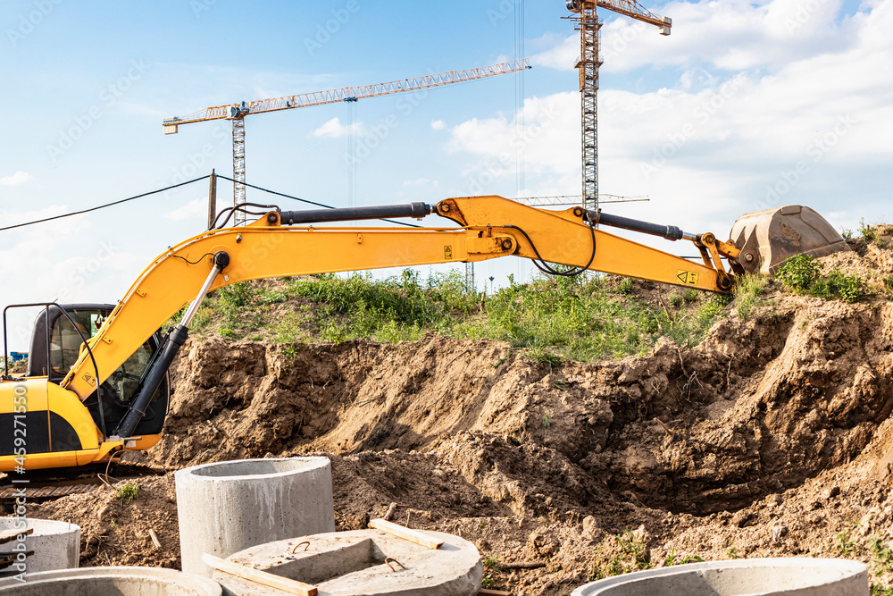 The excavator digs a foundation pit for the installation of sewer wells ...