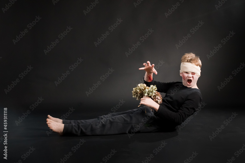 Teenage boy playing an apparition-like resurrected Halloween ghost ...