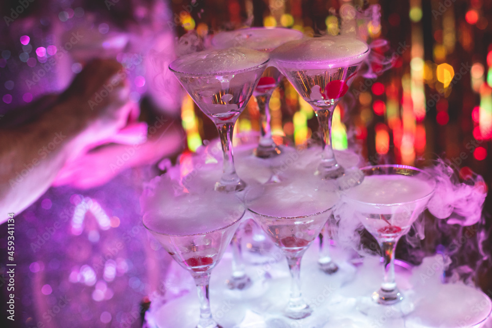 Pyramid of glasses with alcoholic beverages, filling and pouring ...