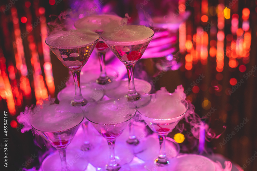 Pyramid of glasses with alcoholic beverages, filling and pouring ...