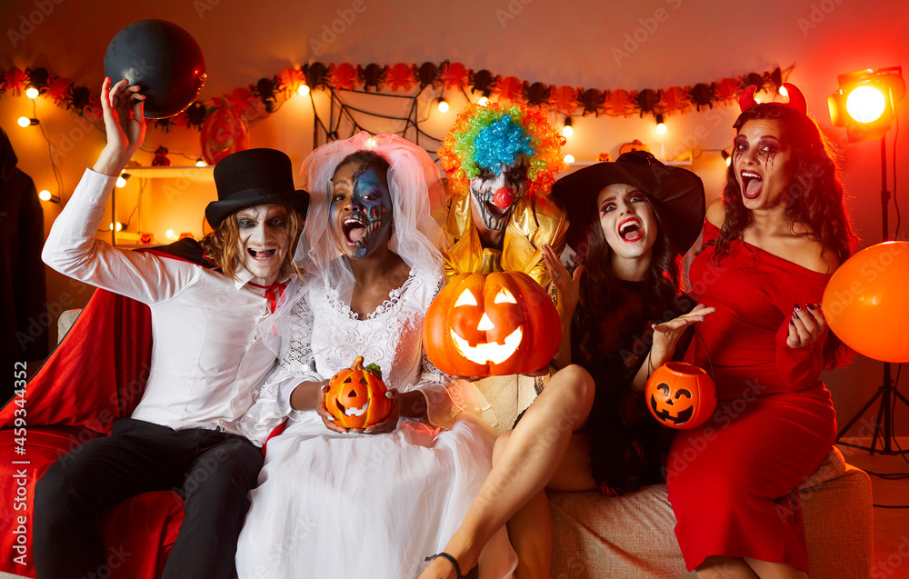 Friends having fun at Halloween party at home. Group portrait of adult ...