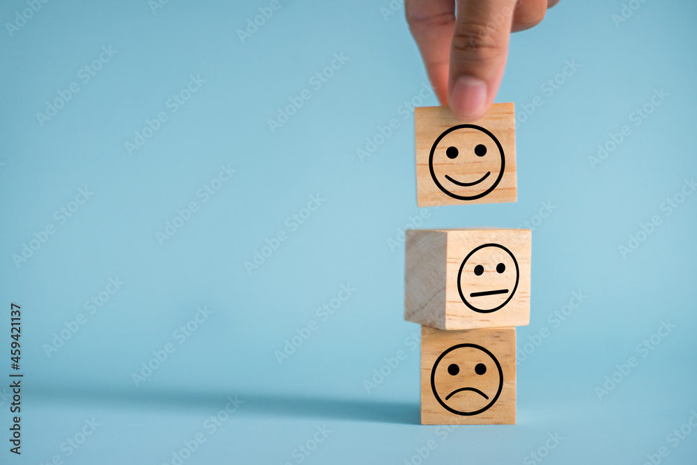 Businessman holding wooden blocks with the happy face smile face symbol ...