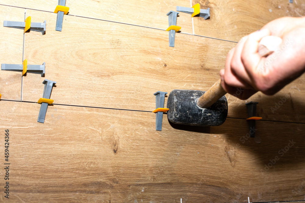 Professional tile laying. Placing or taking out special tile spacers ...