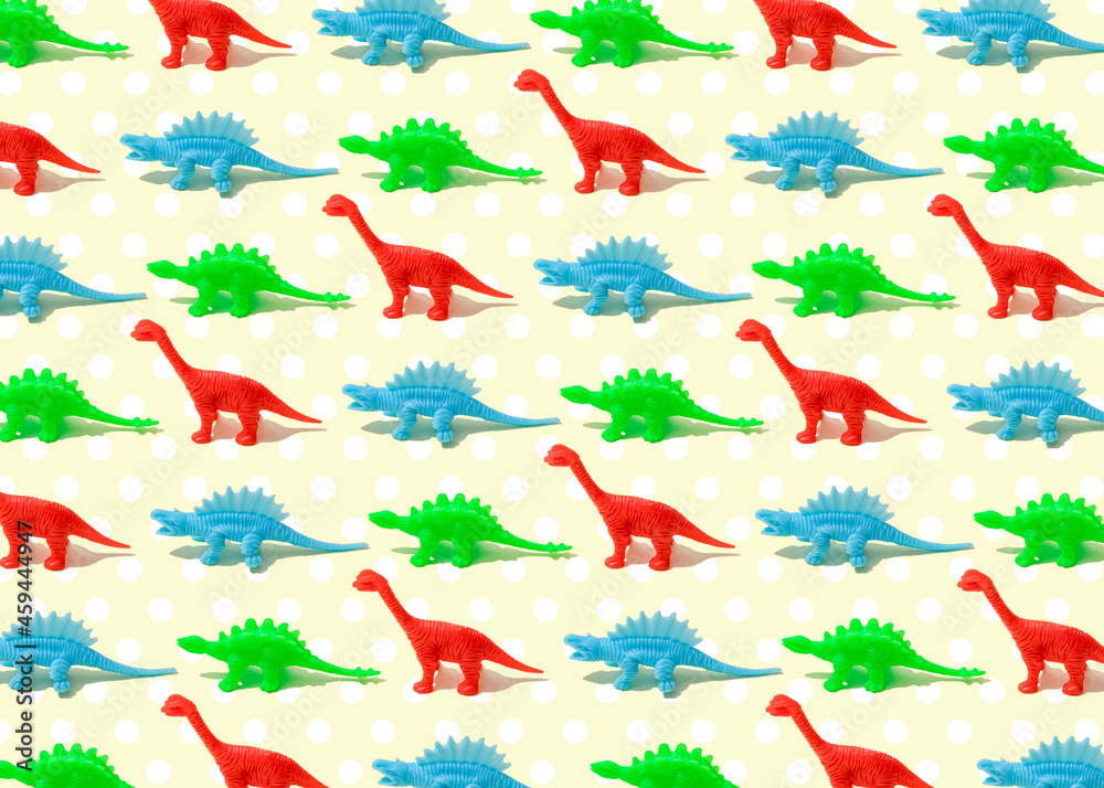 Pattern of green, red and blue plastic dinosaur figurines flat laid ...