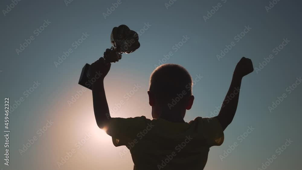 Winner child silhouette. Kid with cup of success raises her hand ...