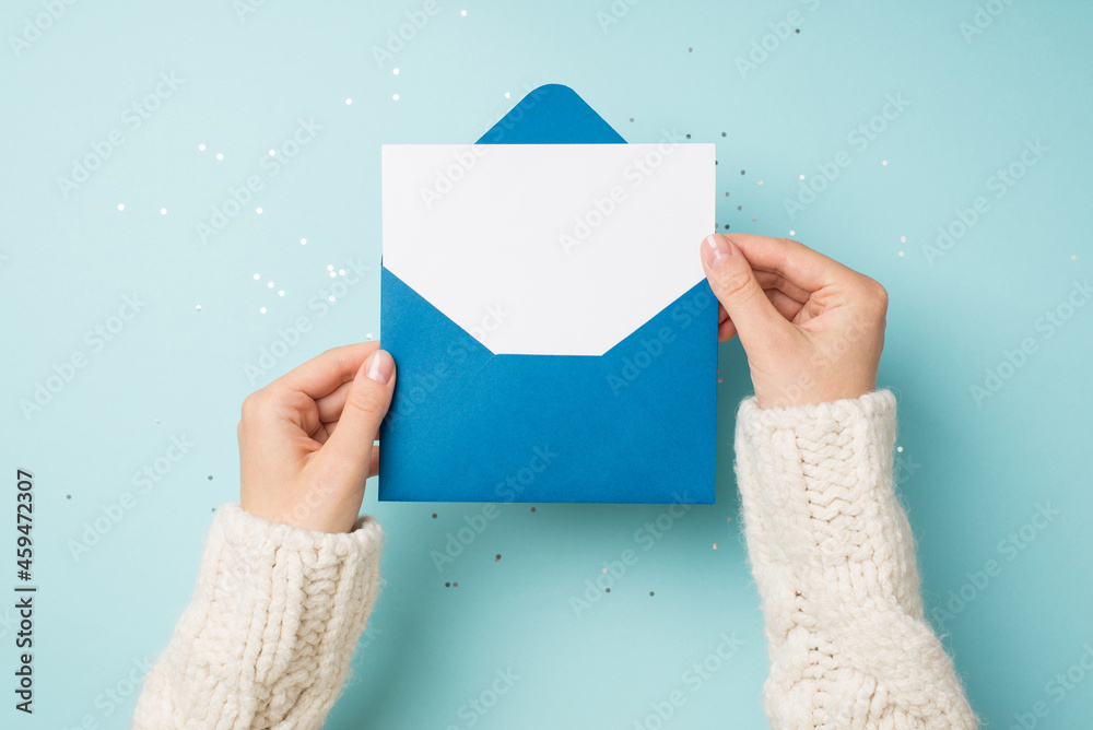 First person top view photo of hands in white sweater holding open blue ...