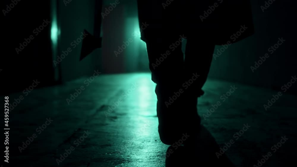 Maniac walking with axe in dark corridor. Mystical scary murderer going ...