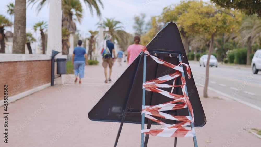 Triangle traffic sign with red and white ribbon in the middle of the ...
