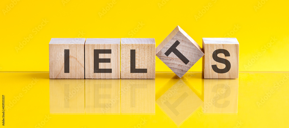 ielts word is made of wooden building blocks lying on the yellow table ...