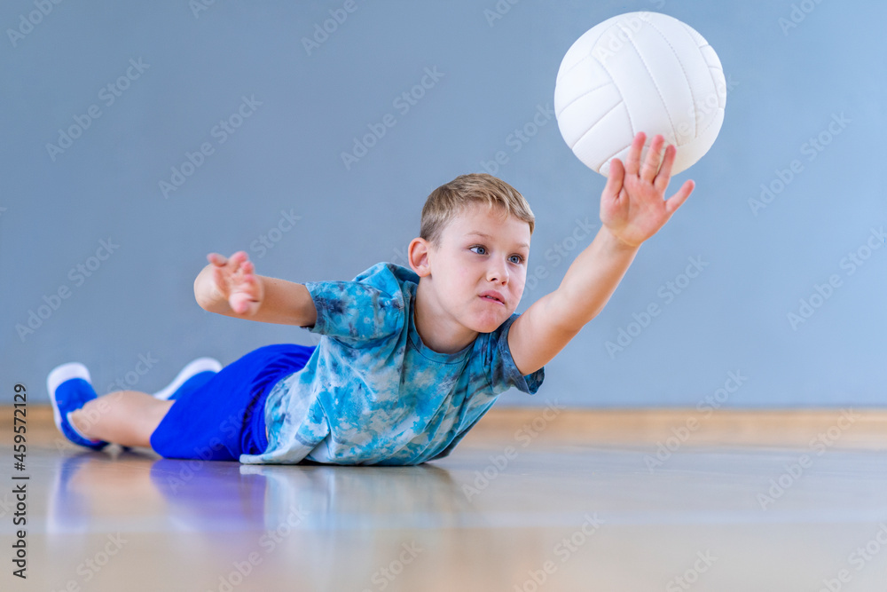 School kid playing volleyball in a physical education lesson ...