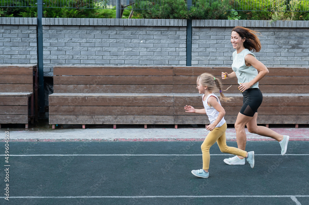 Caucasian woman goes in for sports with her daughter outdoors. A ...
