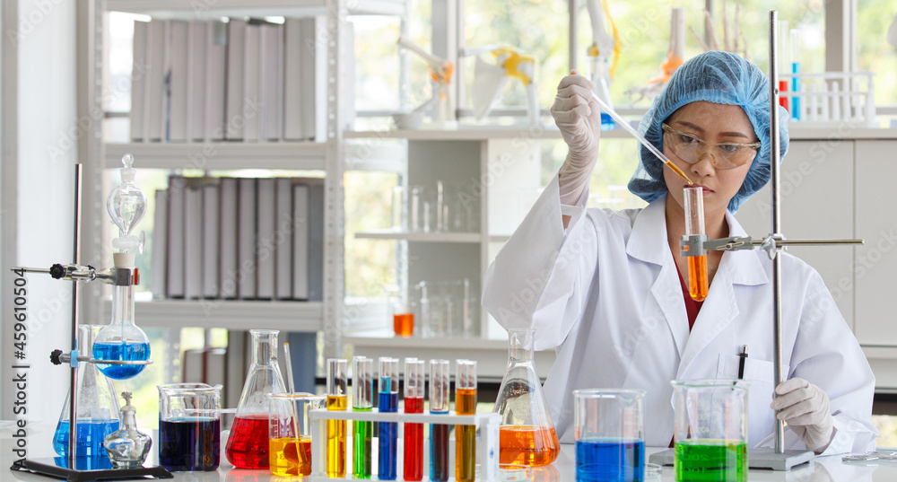 Asian female professional scientist in white lab coat safety glasses ...