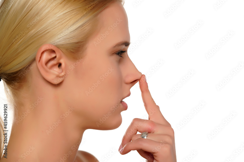 Young blond woman touches her nose with her finger Stock Photo | Adobe ...