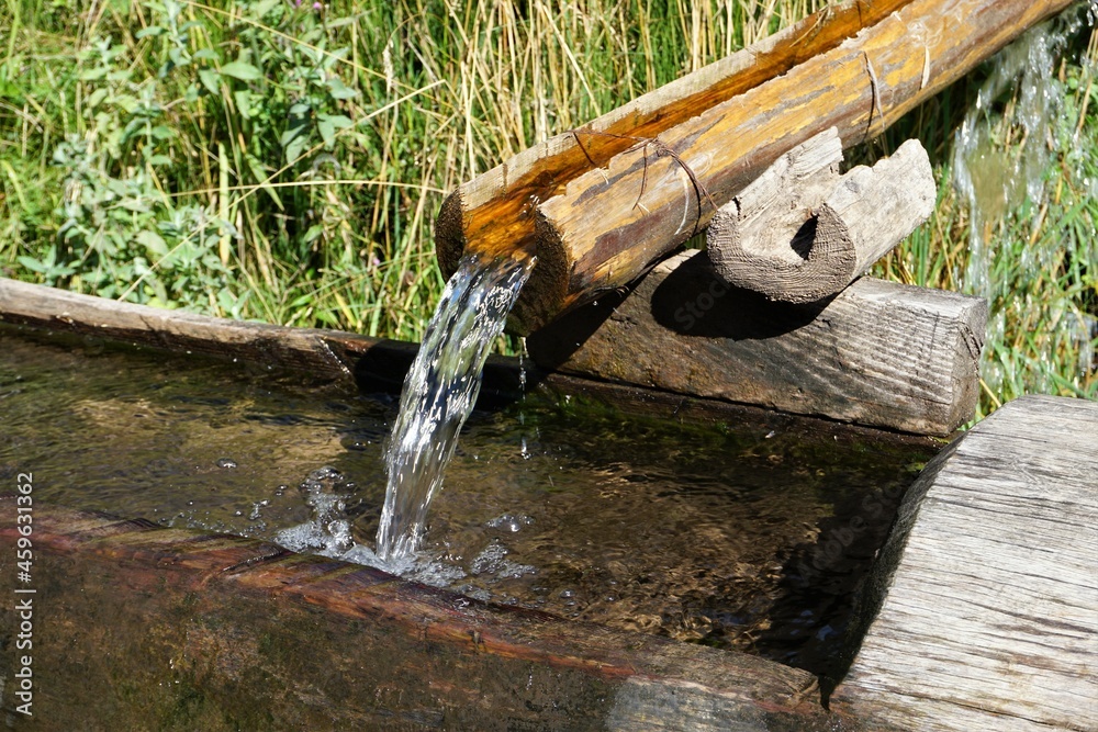 frisches Quellwasser fließt in Holztrog, Quelle, Wasser aus den Bergen ...