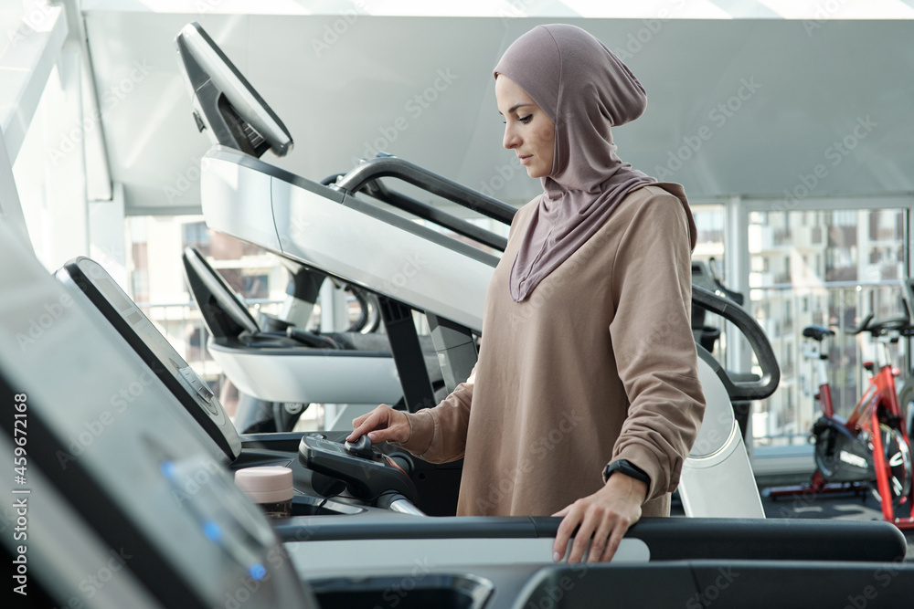 Side view shot of modern Muslim woman wearing hijab starting morning ...