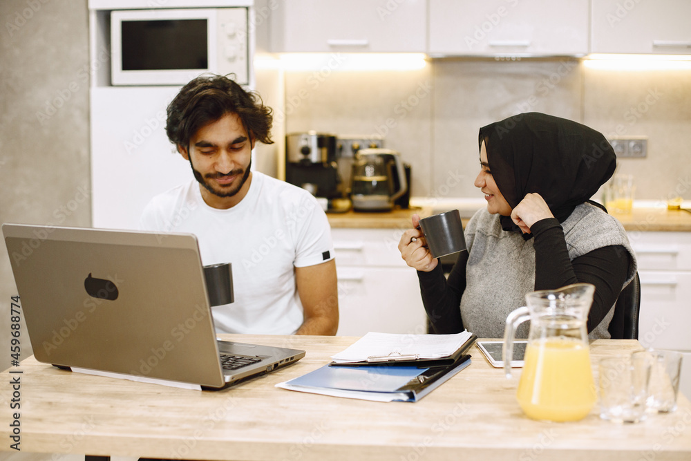 Arab students studying and learning at home with a laptop and notes ...