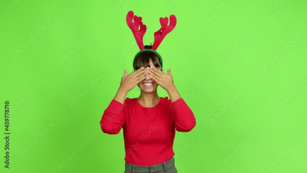 Young Woman Wearing Christmas Hat Covering Eyes By Hands Surprised To