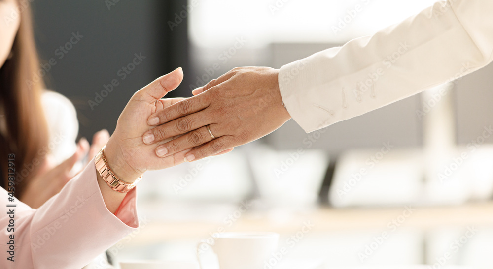 Businesspeople walking through into office passed row of businesswomen ...