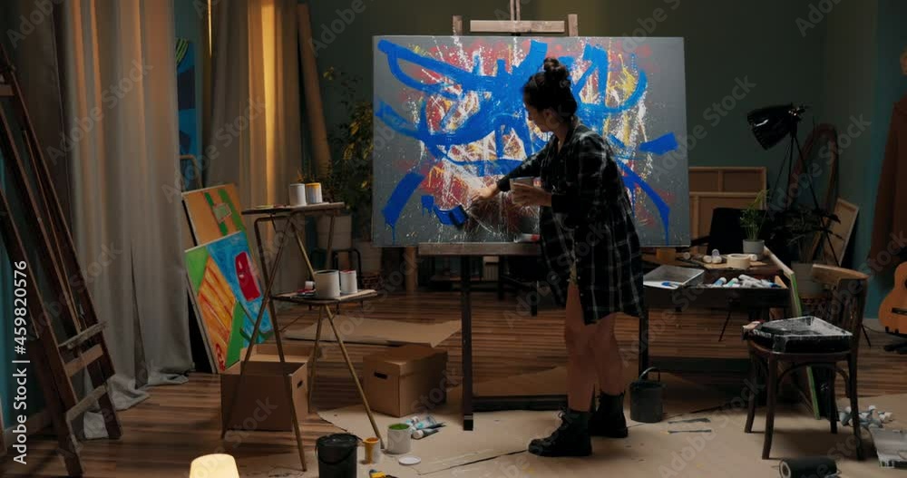 Talented artist hand paints oil paintings with blue paint with gentle ...