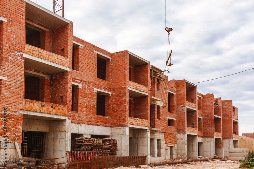 Construction Site. Сrane lifts the beam, Pile of sand and shovel at the ...