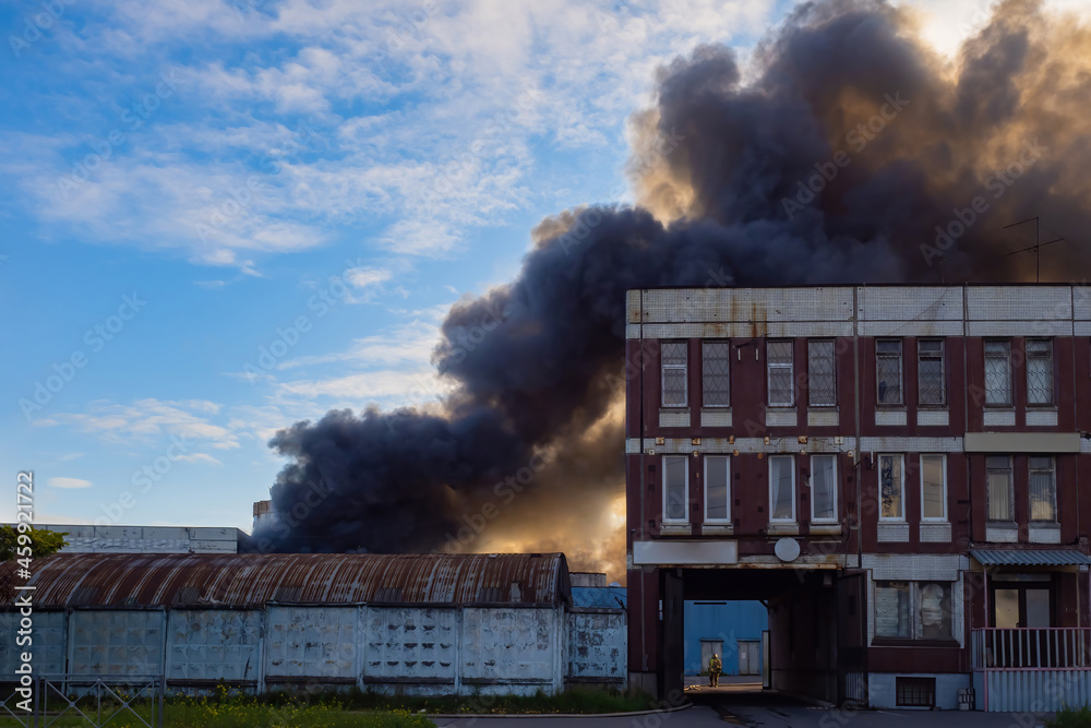 Fire in old factory. Puffs of black smoke from fire. Industrial ...