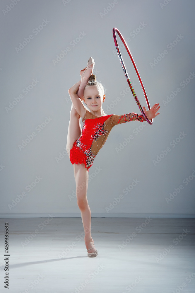 Image of flexible little girl doing vertical split with hula hoop in ...
