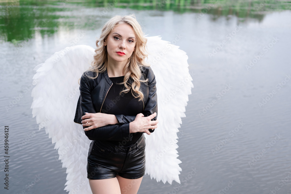 woman with white angel wings. wearing black leather clothes. fallen ...