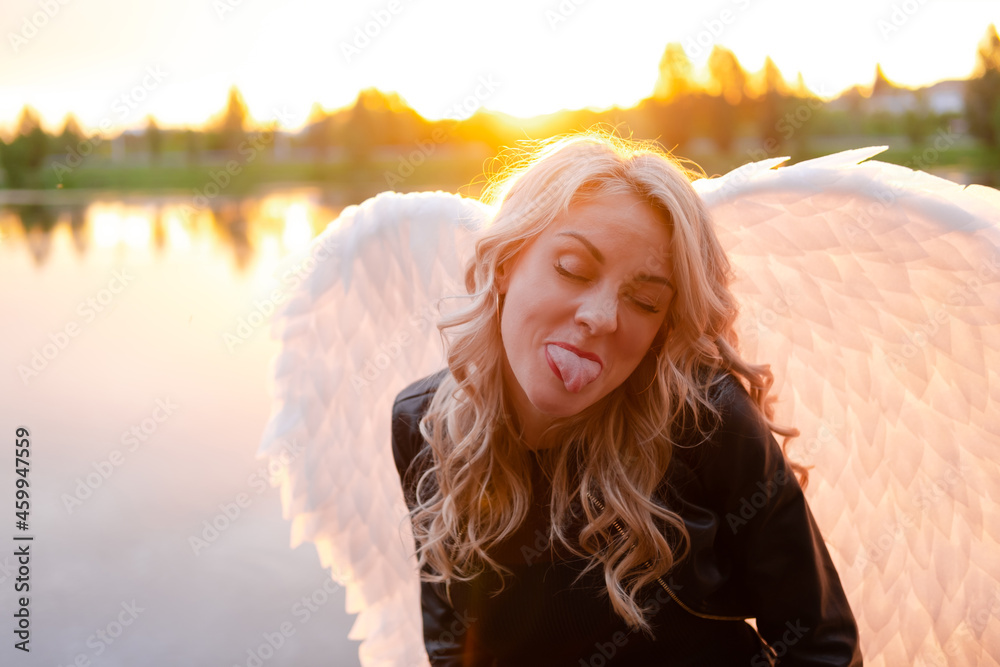 woman with white angel wings. wearing black leather clothes. fallen ...