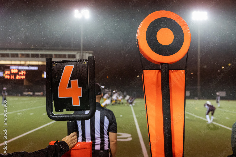 American football fourth down marker behind referee on rainy game day ...