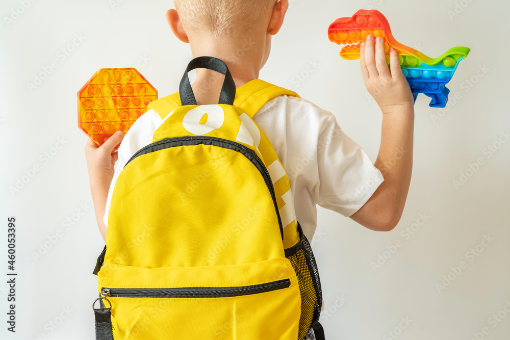 Child with school bag and Sensory Fidget Toy on white background. Back ...