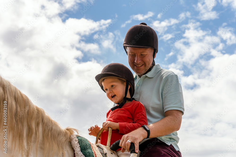 Father and son riding horse in the paddock Stock Photo | Adobe Stock