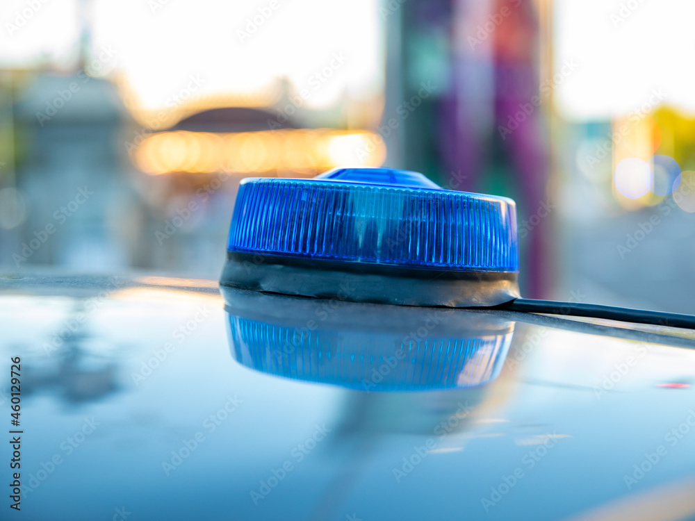 blue lights on the roof of a police car with the background out of ...