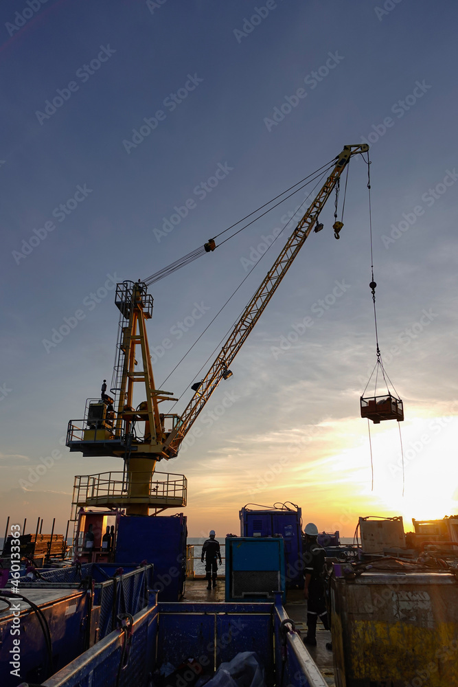 Basket lifting by crane on offshore installation. Cargo operations on ...