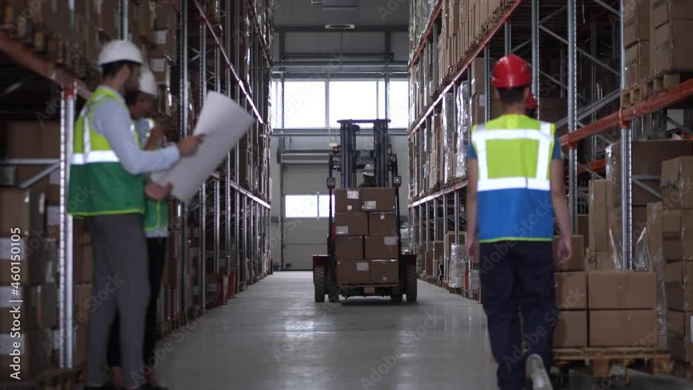 Storehouse employees at work, two logistics managers examining layout ...