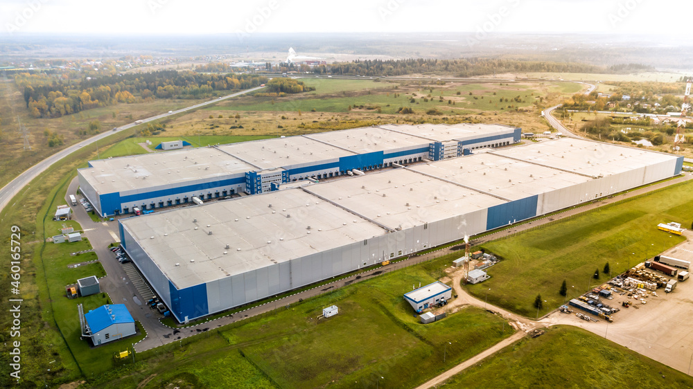 Aerial shot of industrial warehouse. Loading hub and many trucks with ...
