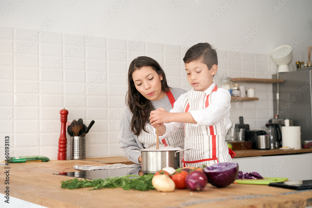 In the kitchen: A single-parent family cooking pasta together. Mother ...