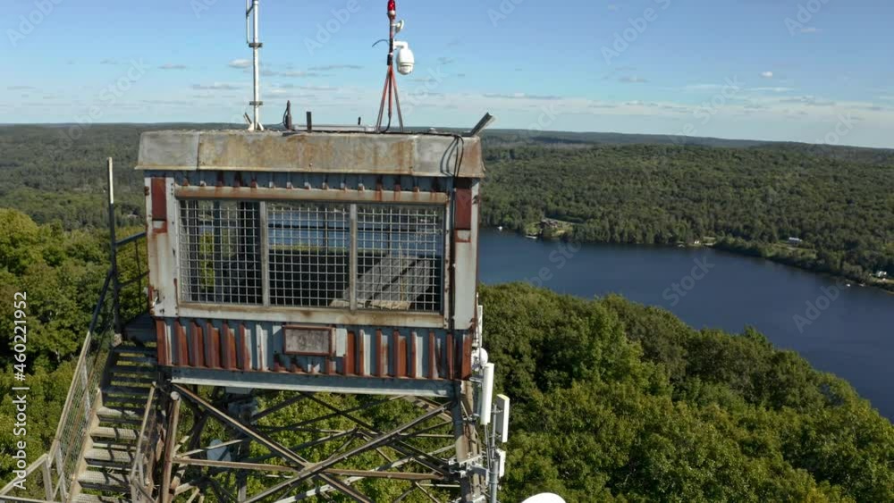 Drone shot rotating around rusty lookout tower will cell equipment ...