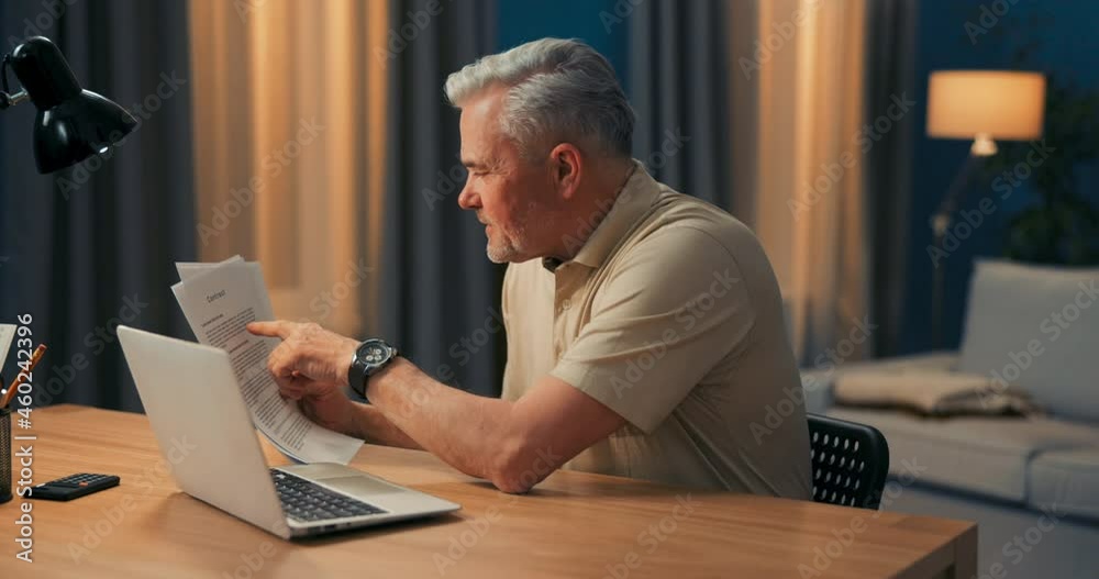 Vídeo do Stock: man sits in front of computer in living room in evening ...