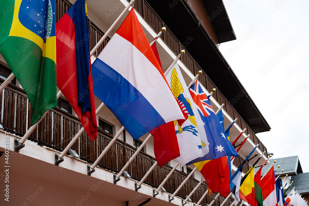 Many flags of different states fluttering on the facade of building ...