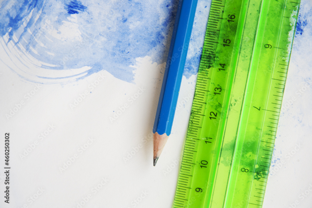 Green ruler and pencil on the blank sheet. Background of the page with ...