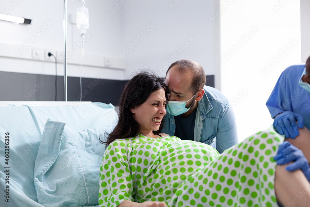 Pregnant woman pushing for childbirth having contractions in hospital ...