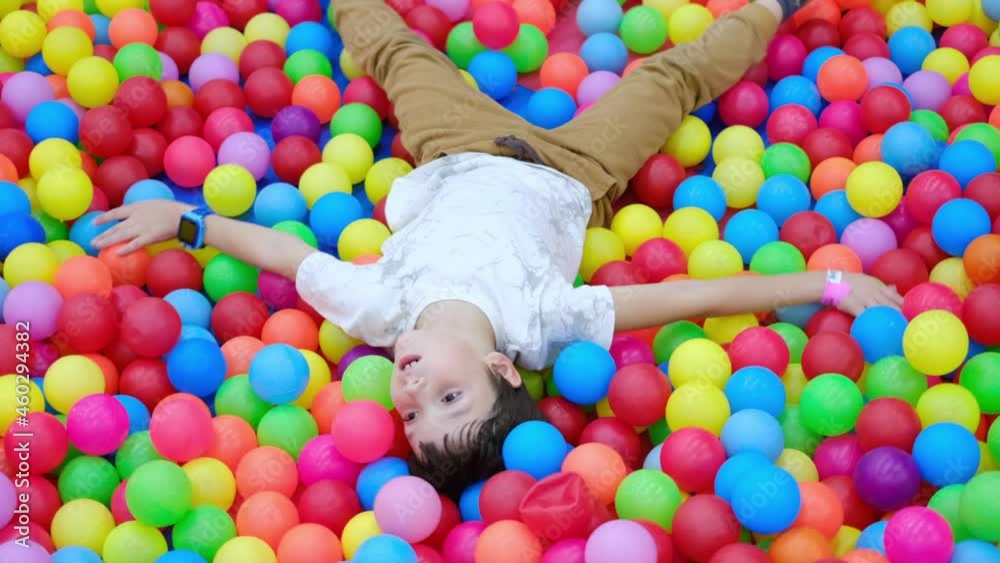 Boy falling down into pool with colored balls, autism spectrum disorder ...
