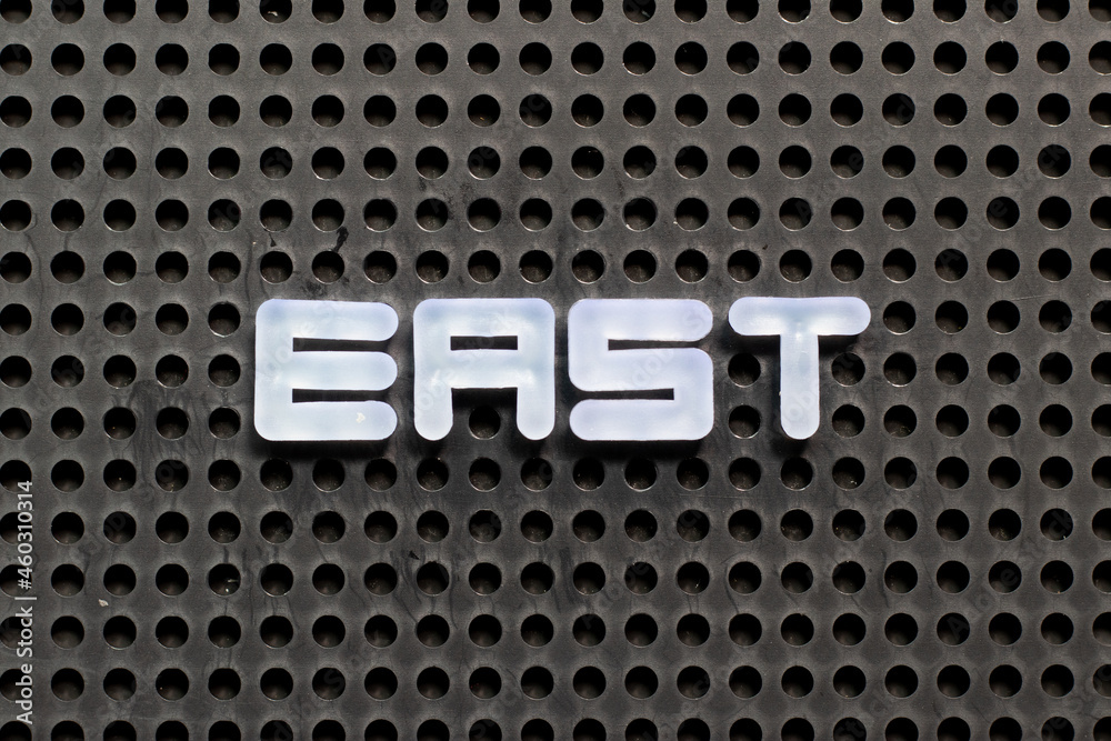 White color letter in word east on black pegboard background Stock ...