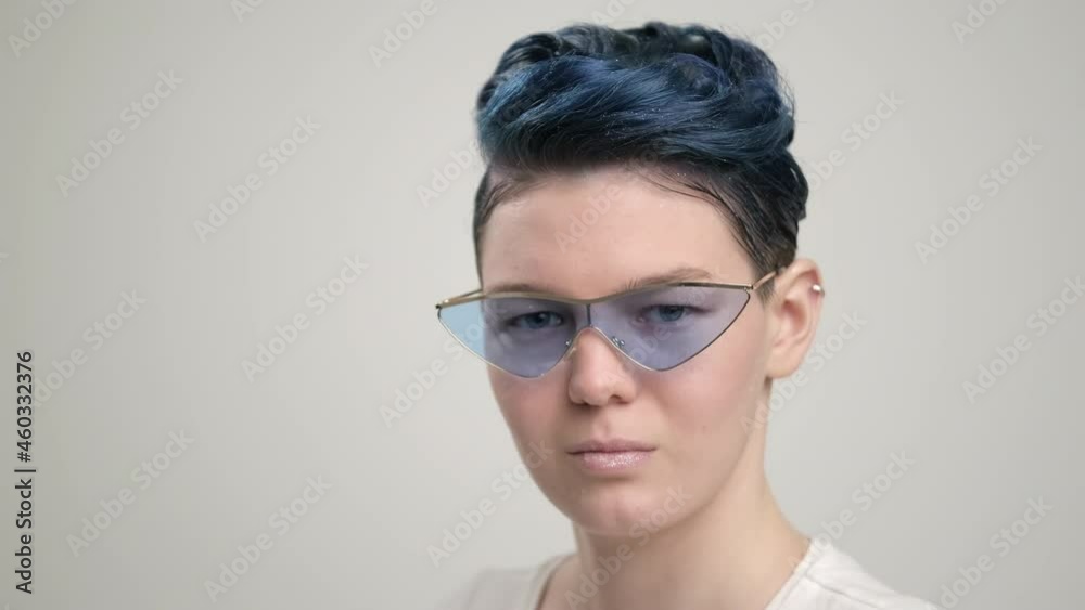 Vídeo do Stock: A young girl with a short pixie haircut and dark blue ...