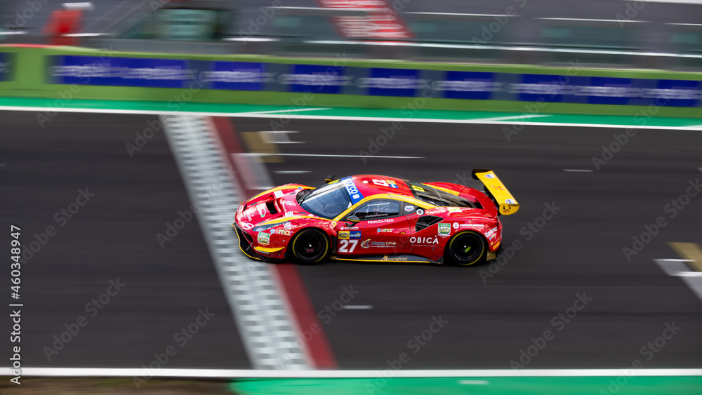 Fast Ferrari 488 touring crossing checkered line on race track ...