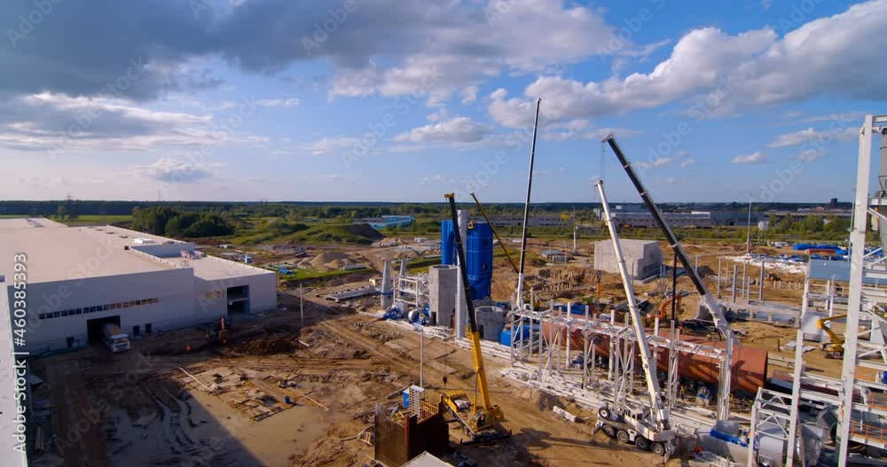 At the construction site where a new, modern plant is being built, a ...