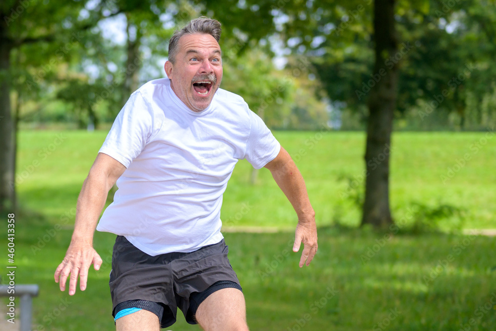 Man using low bars in a park as hurdles as he runs along a path Stock ...