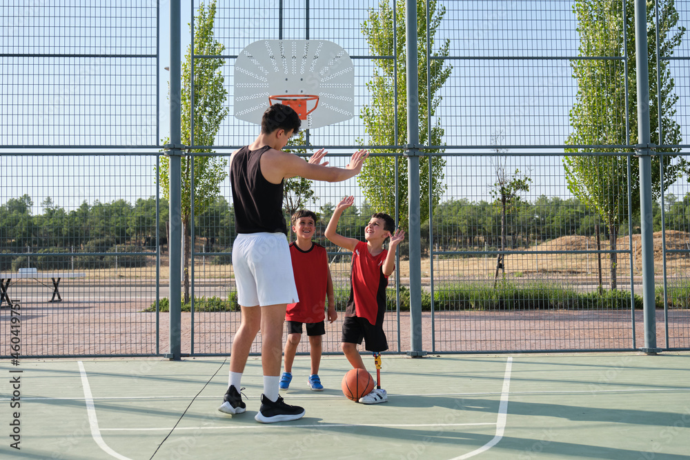 Siblings smile and high five with their older brother, one has a leg ...