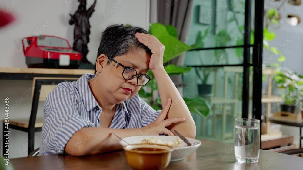 elderly woman sitting alone at home eating breakfast alone . elderly ...