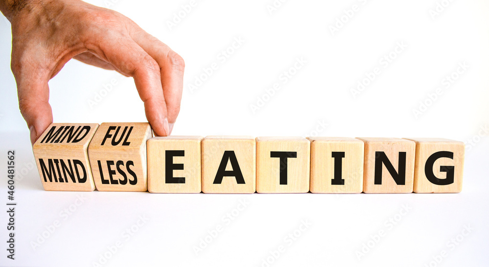 Mindful or mindless eating symbol. Doctor turns cubes and changes words ...